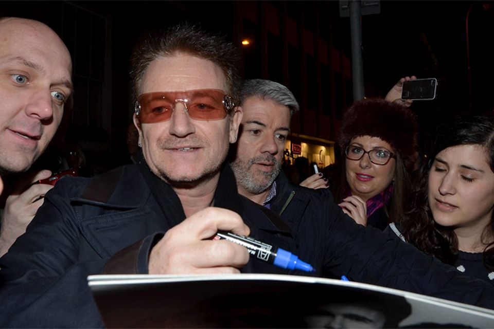 On the streets again: Bono thrills shoppers with his annual Christmas ...